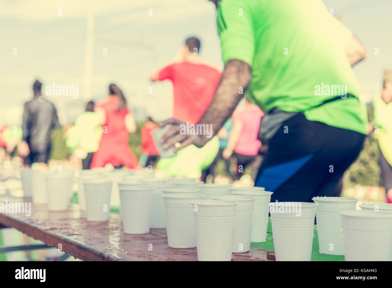 Runner taking a cup of water at H20 stand Stock Photo - Alamy