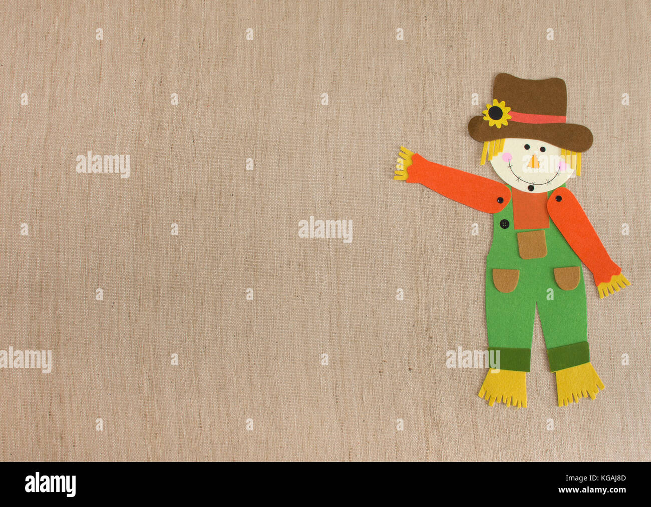 A waving felt scarecrow on the right wearing orange, yellow, bright ...