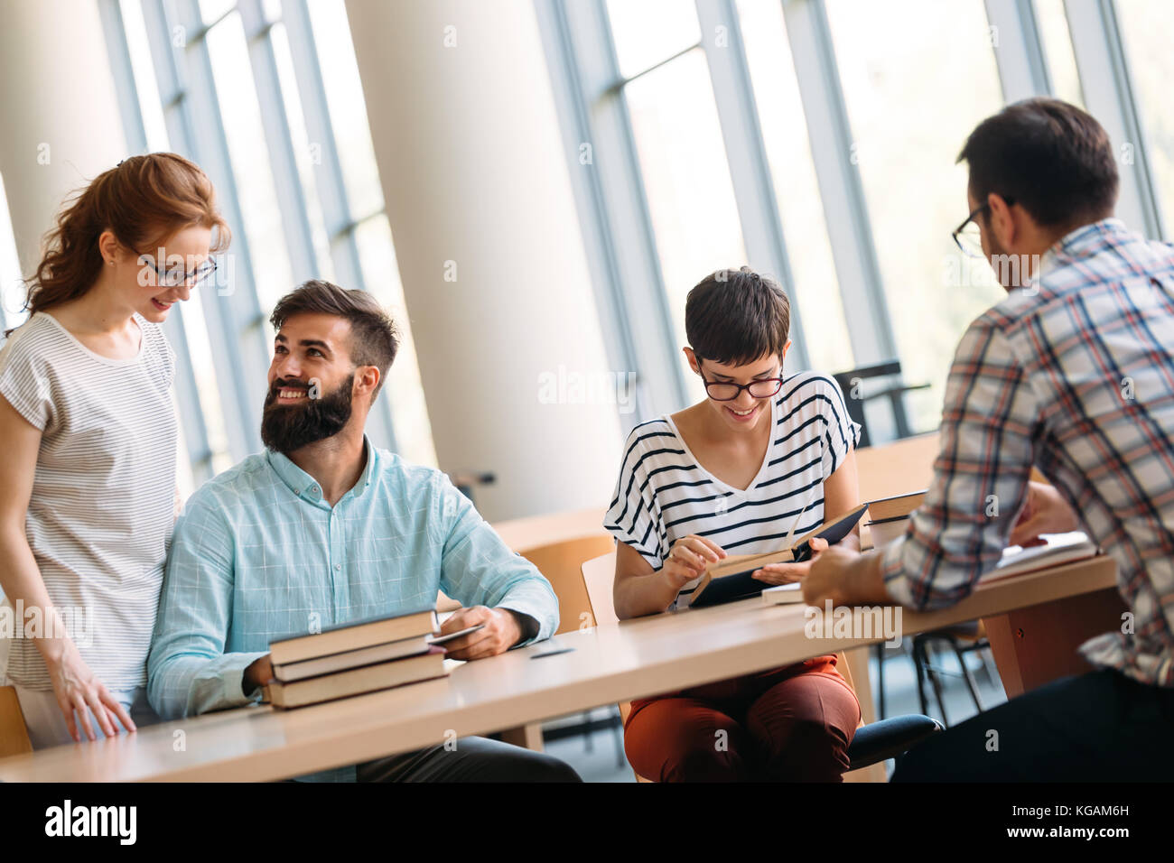 Group of students discussing in university library Stock Photo - Alamy