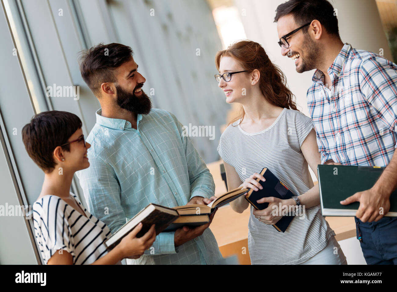Group of students discussing in university library Stock Photo - Alamy