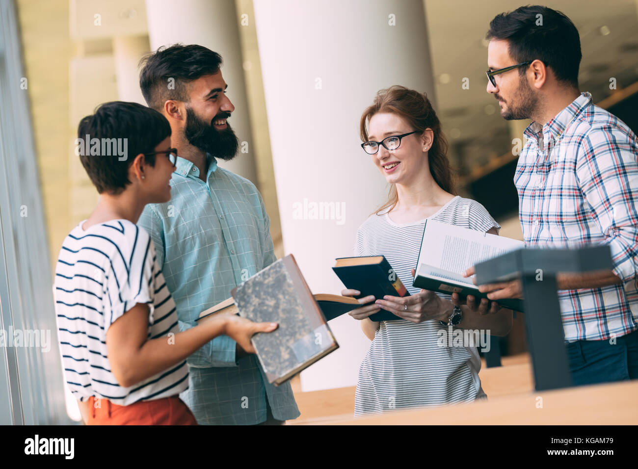 Group of students discussing in university library Stock Photo - Alamy