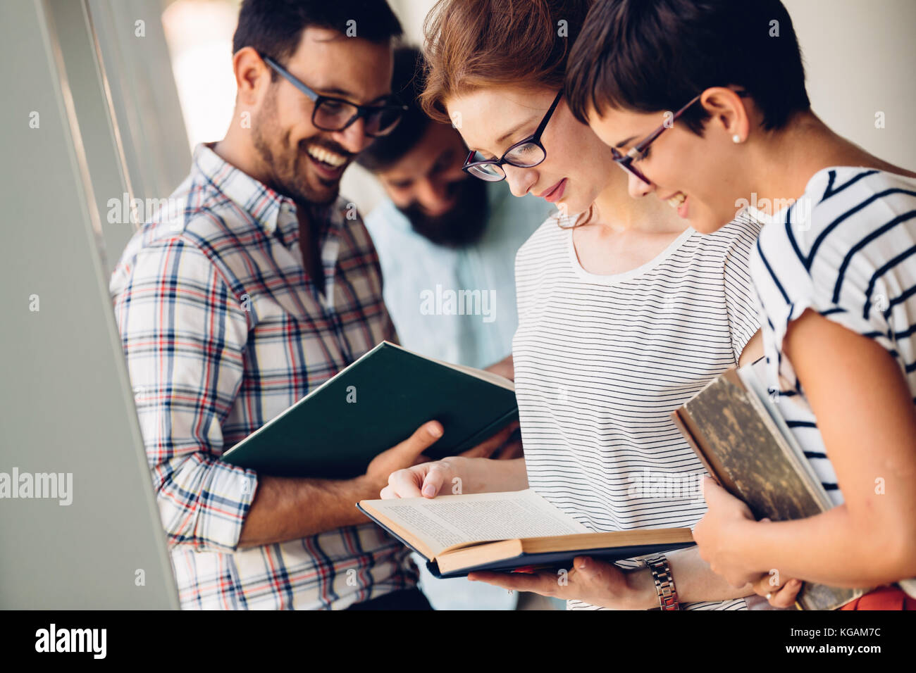 Group of students discussing in university library Stock Photo - Alamy