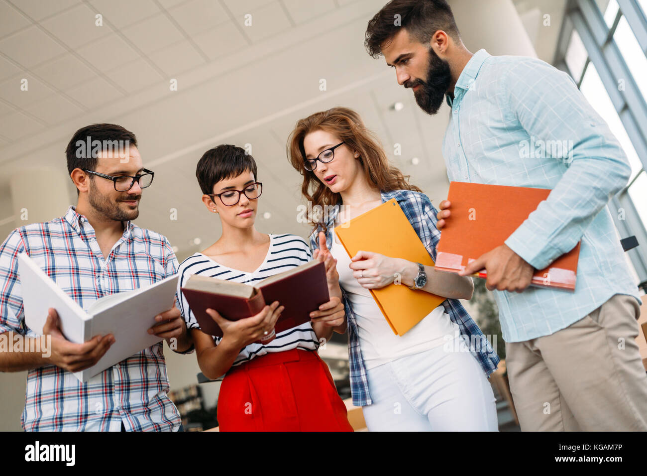 Group of students discussing in university library Stock Photo - Alamy