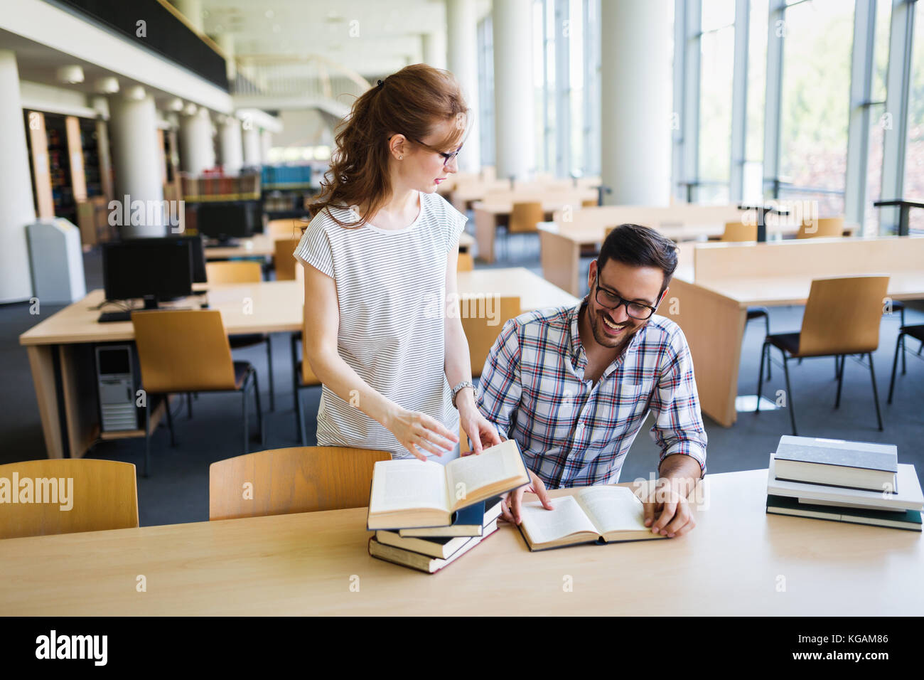 Young attractive students spending time in library Stock Photo - Alamy