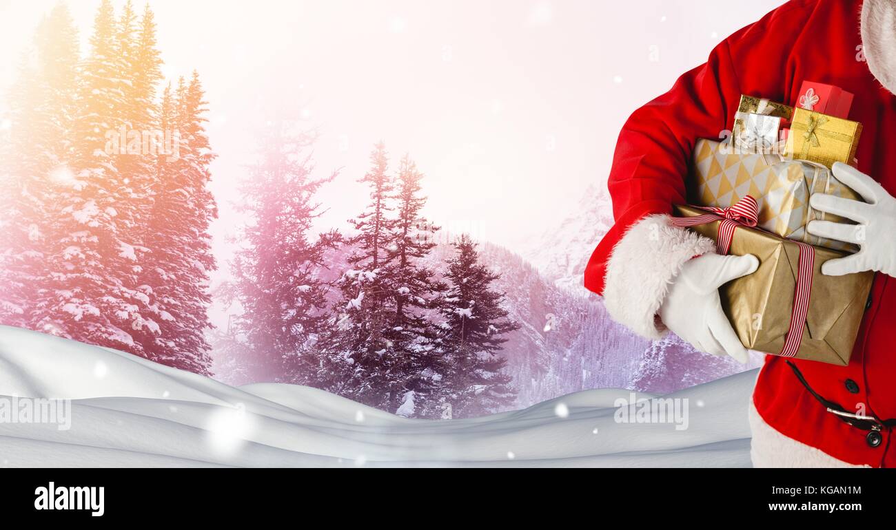 Digital composite of Santa holding gifts in Christmas Winter landscape ...