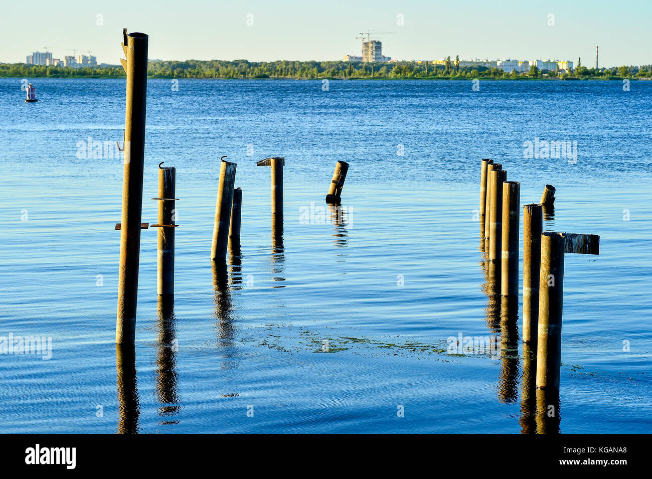 Wooden posts for the berth of boats and boats on the reservoir Stock ...
