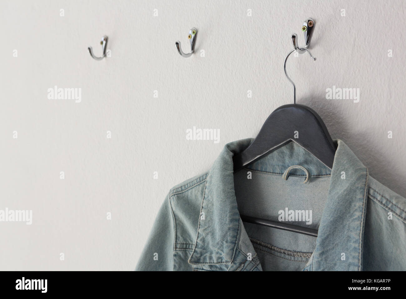 Close-up of denim jacket hanging on hook Stock Photo - Alamy