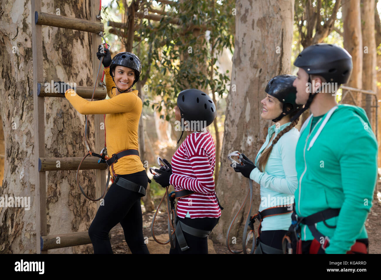 Happy friends climbing on tree with stairs in park Stock Photo - Alamy