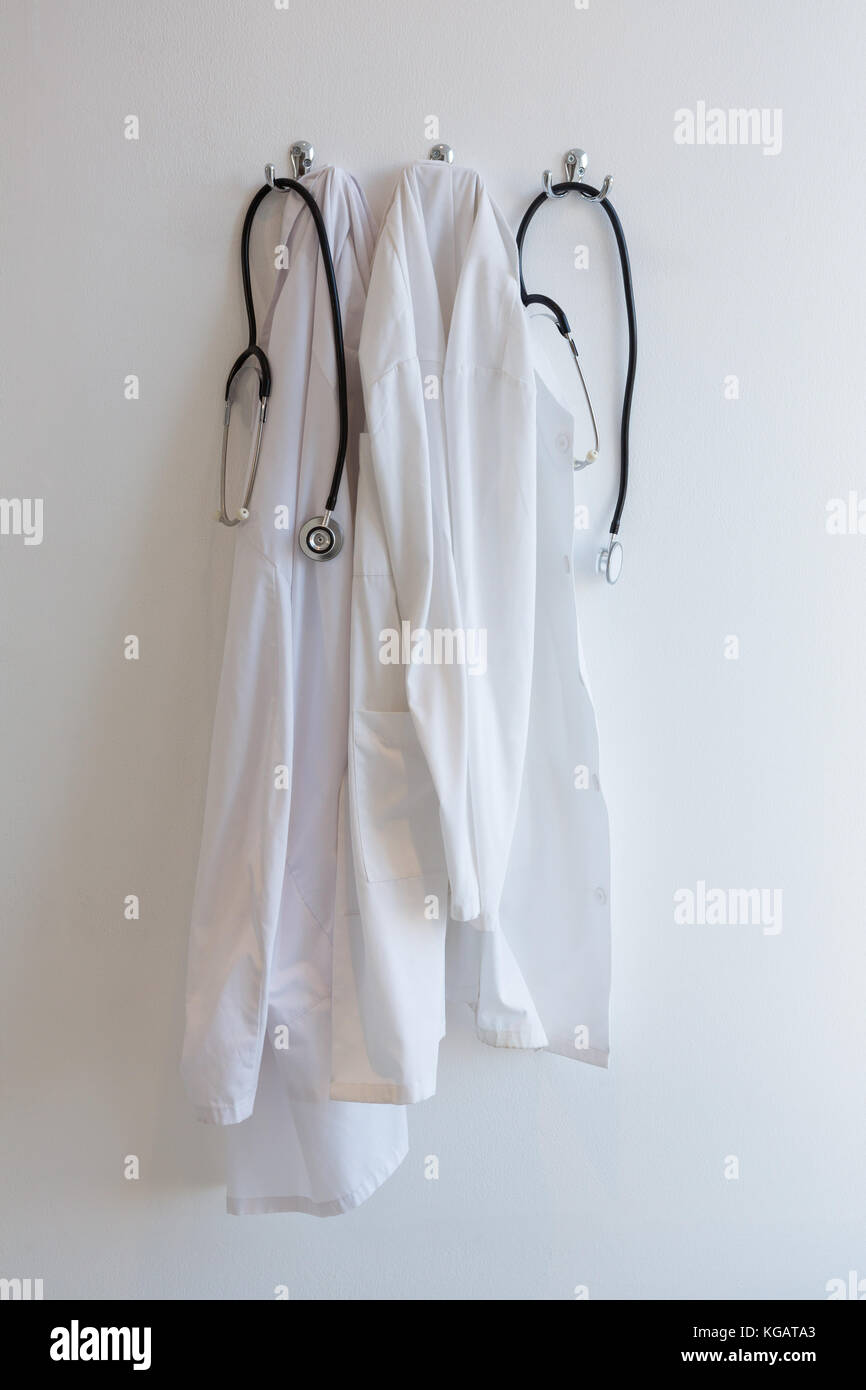 Laboratory coat and stethoscope hanging on hook against wall Stock ...
