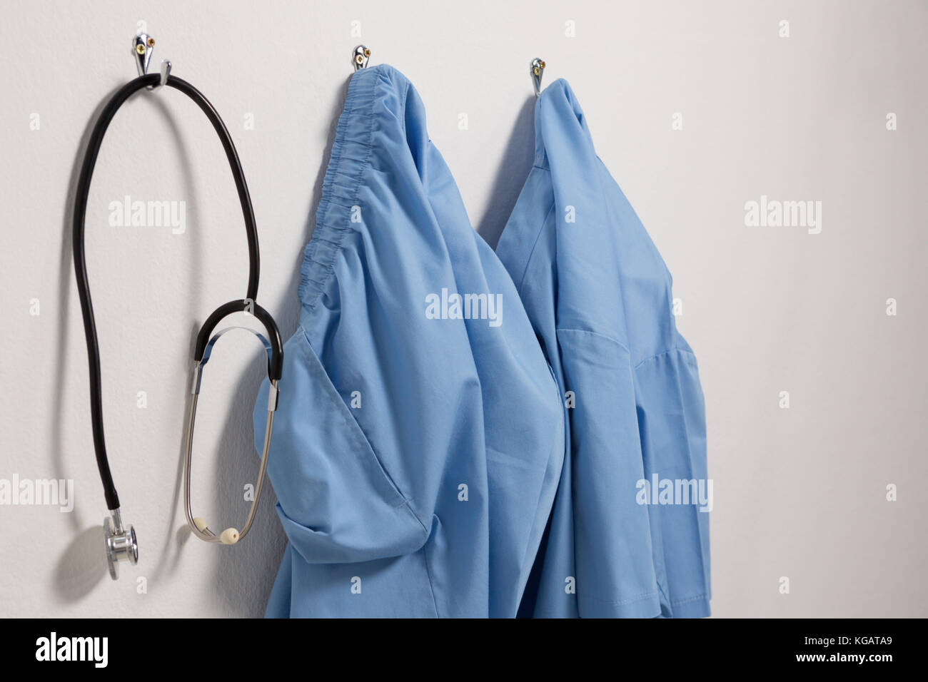 Close-up of scrubs and stethoscope hanging on hook Stock Photo - Alamy
