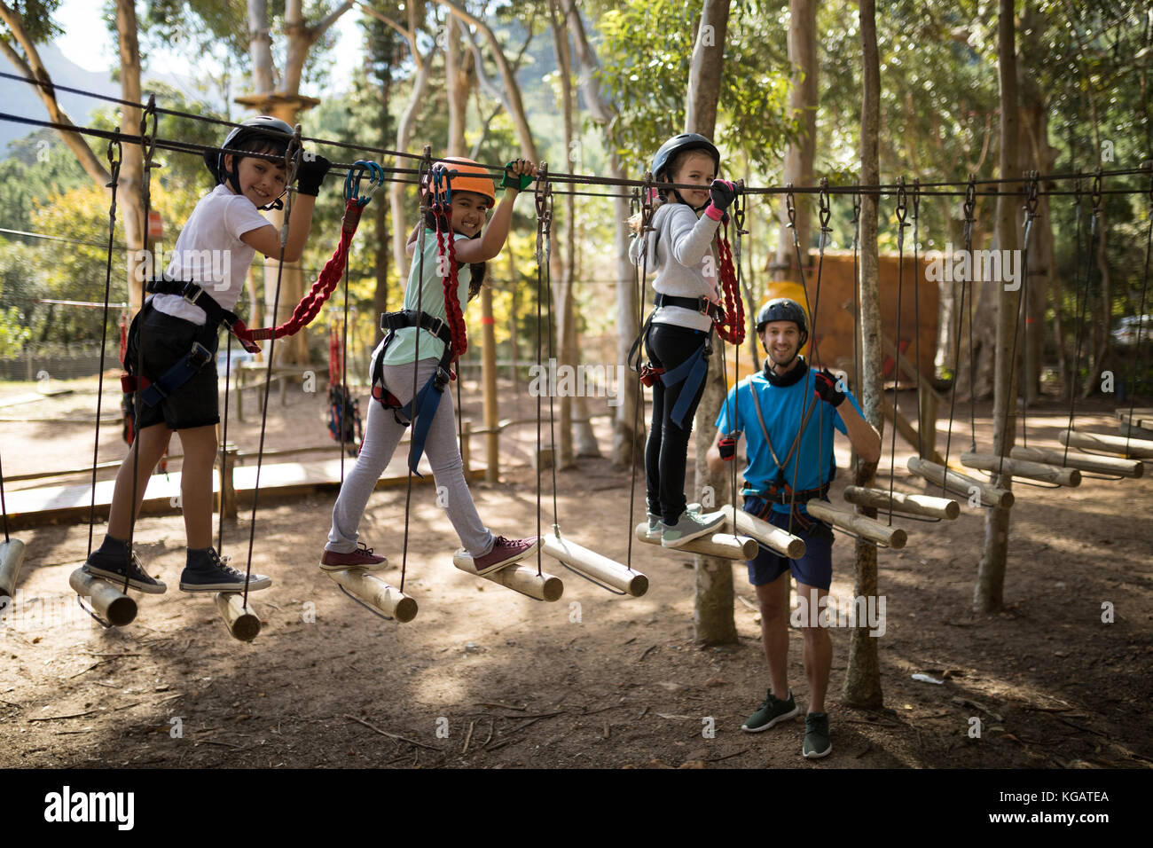 Kids walking on rope bridge in park on a sunny day Stock Photo - Alamy