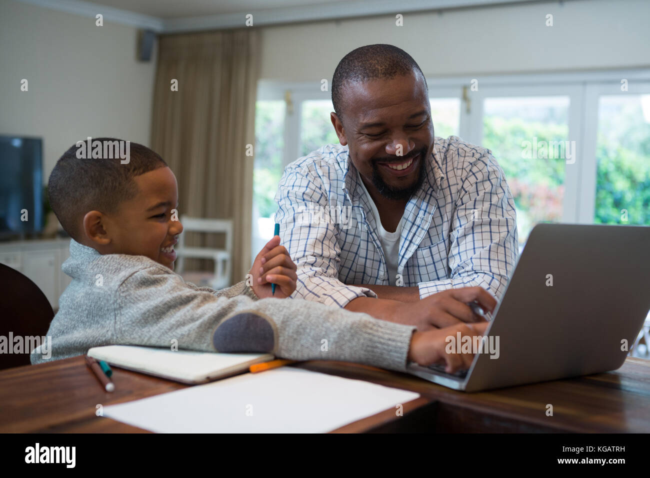 Father and son using laptop in living room at home Stock Photo - Alamy
