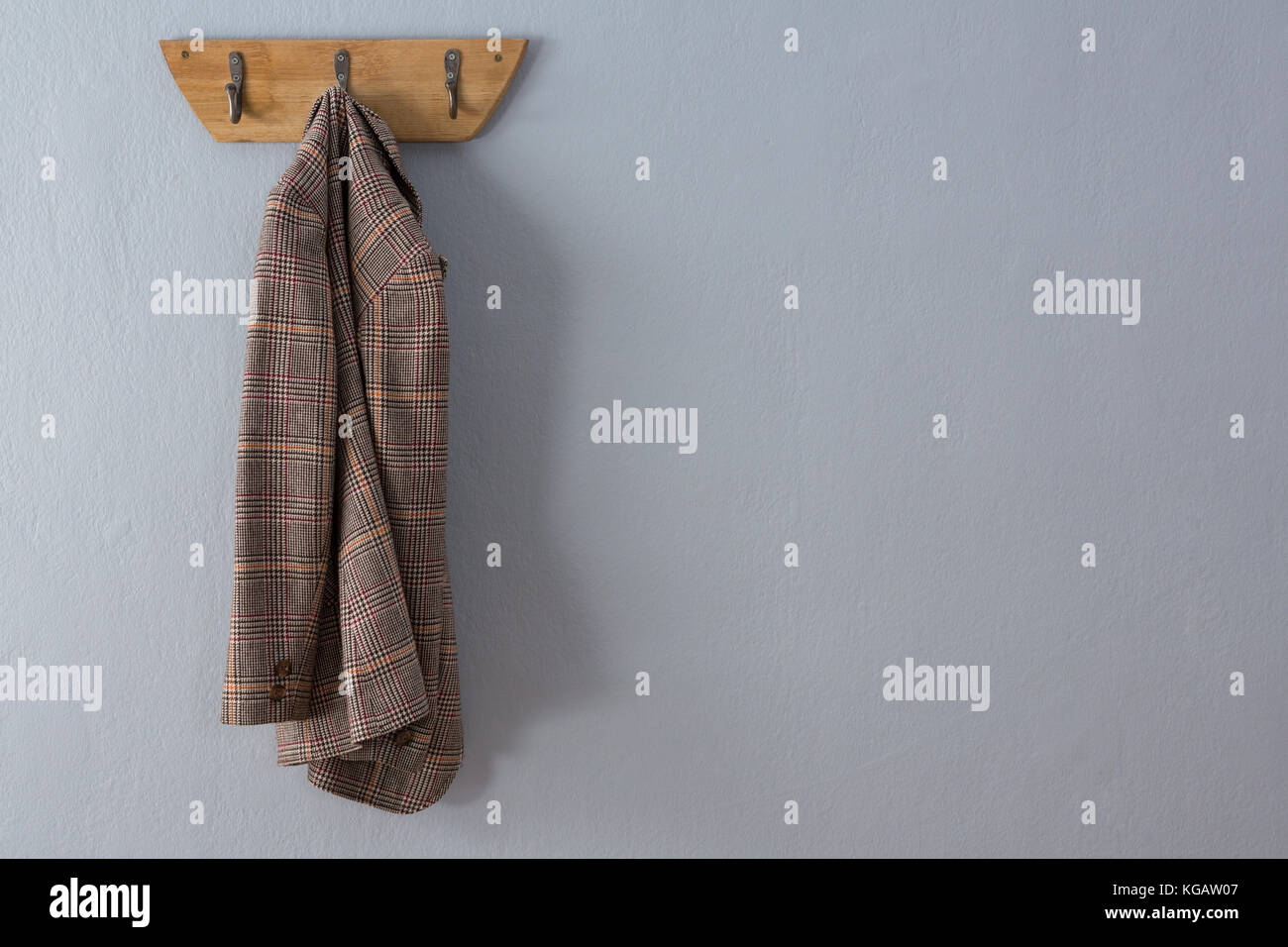 Blazer hanging on hook against wall Stock Photo - Alamy