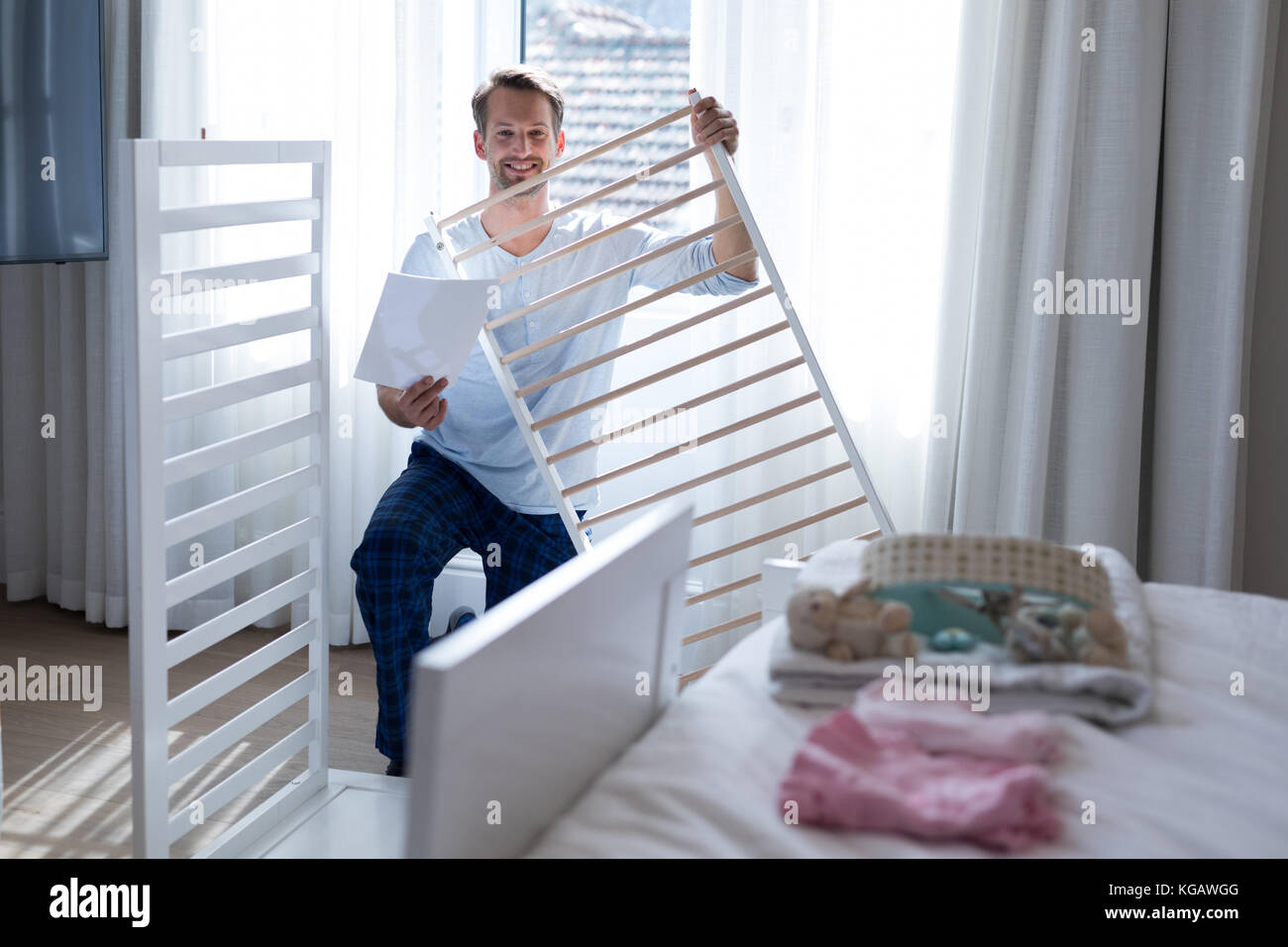 Portrait of man making cot in bedroom Stock Photo - Alamy