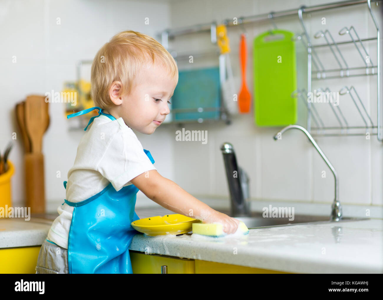 blonde toddler boy playing in kitchen Stock Photo - Alamy