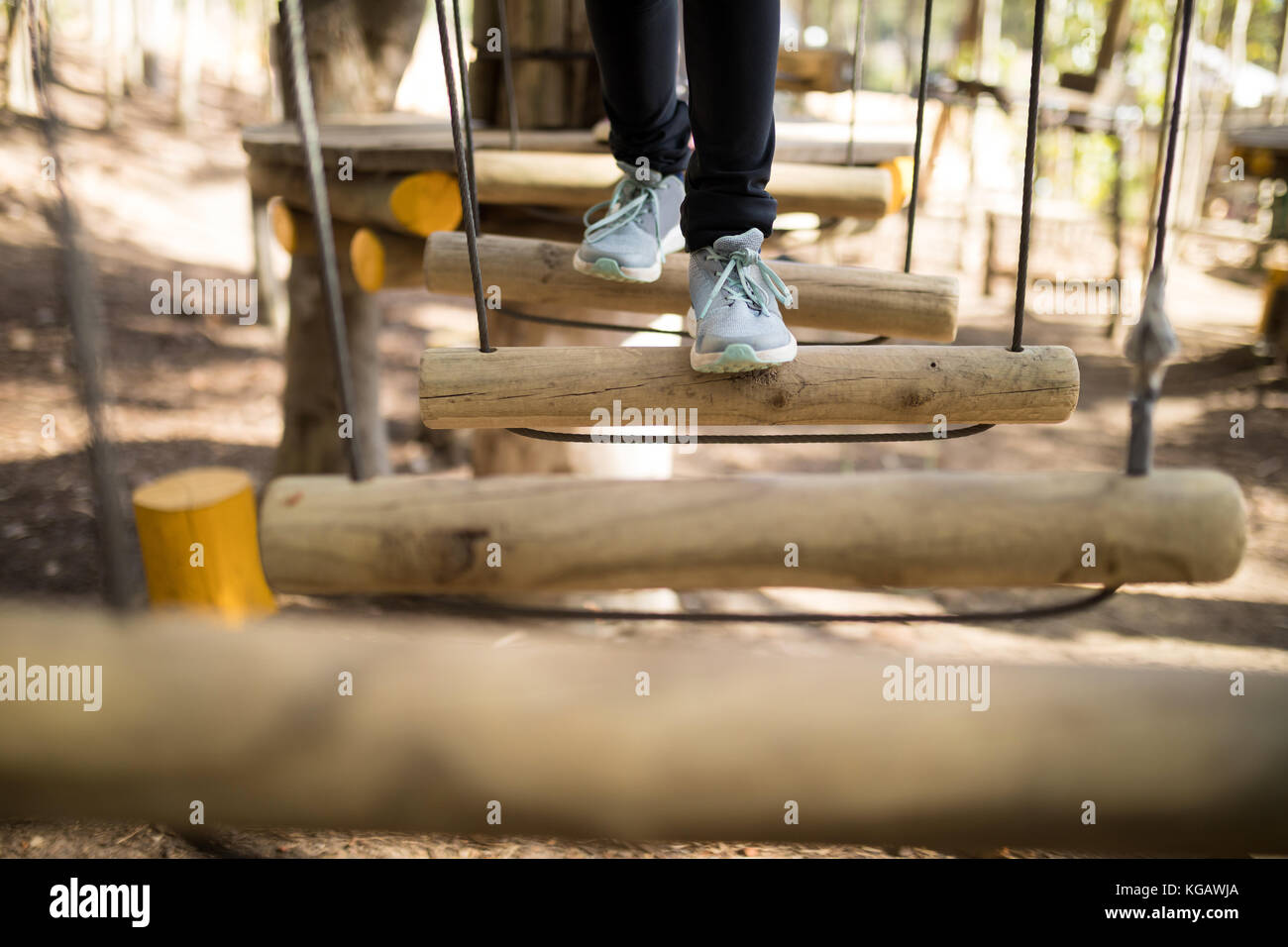 Low section of kid crossing zip line on a sunny day Stock Photo - Alamy
