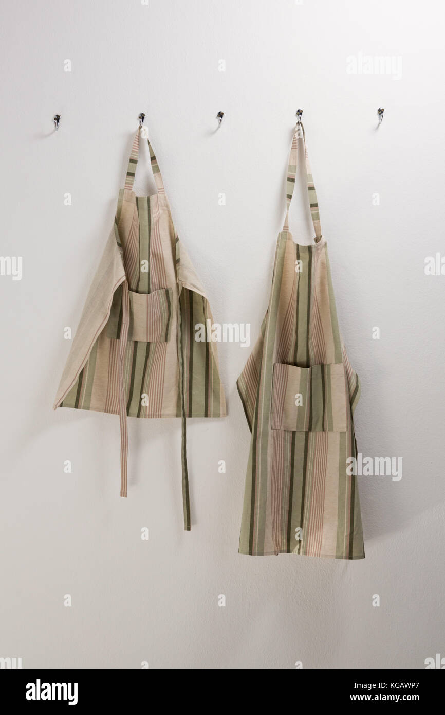 Aprons hanging on hook against wall Stock Photo - Alamy
