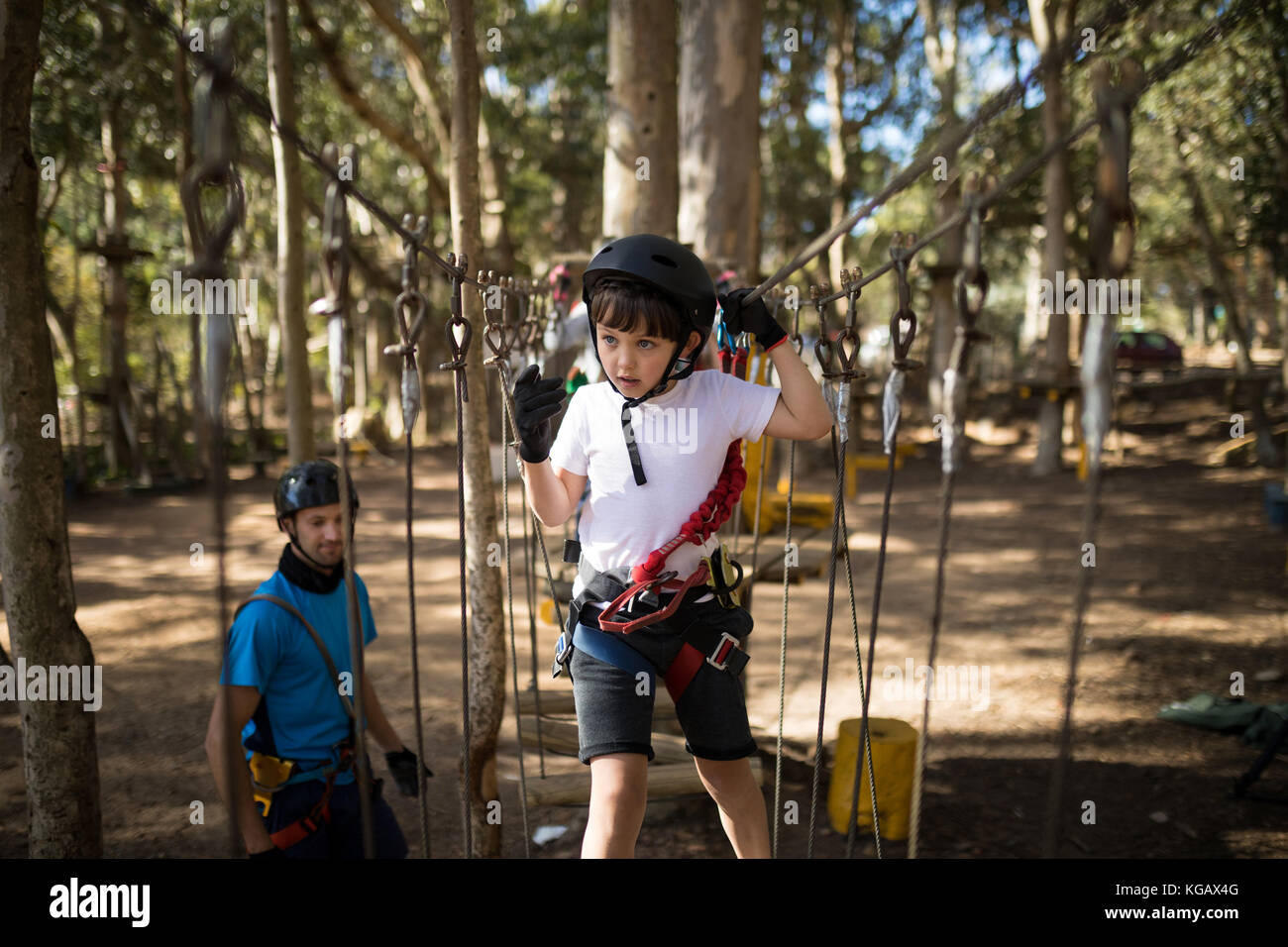 Cute boy crossing zip line in parkland on a sunny day Stock Photo - Alamy