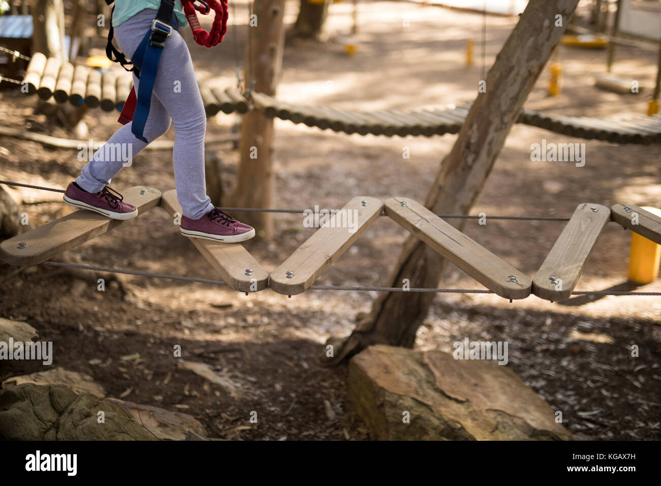 Low section of kid crossing zip line on a sunny day Stock Photo - Alamy