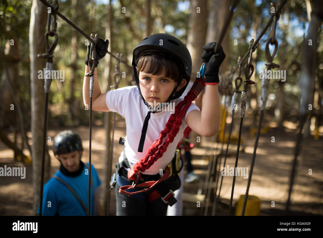 Determined boy crossing zip line on a sunny day Stock Photo - Alamy