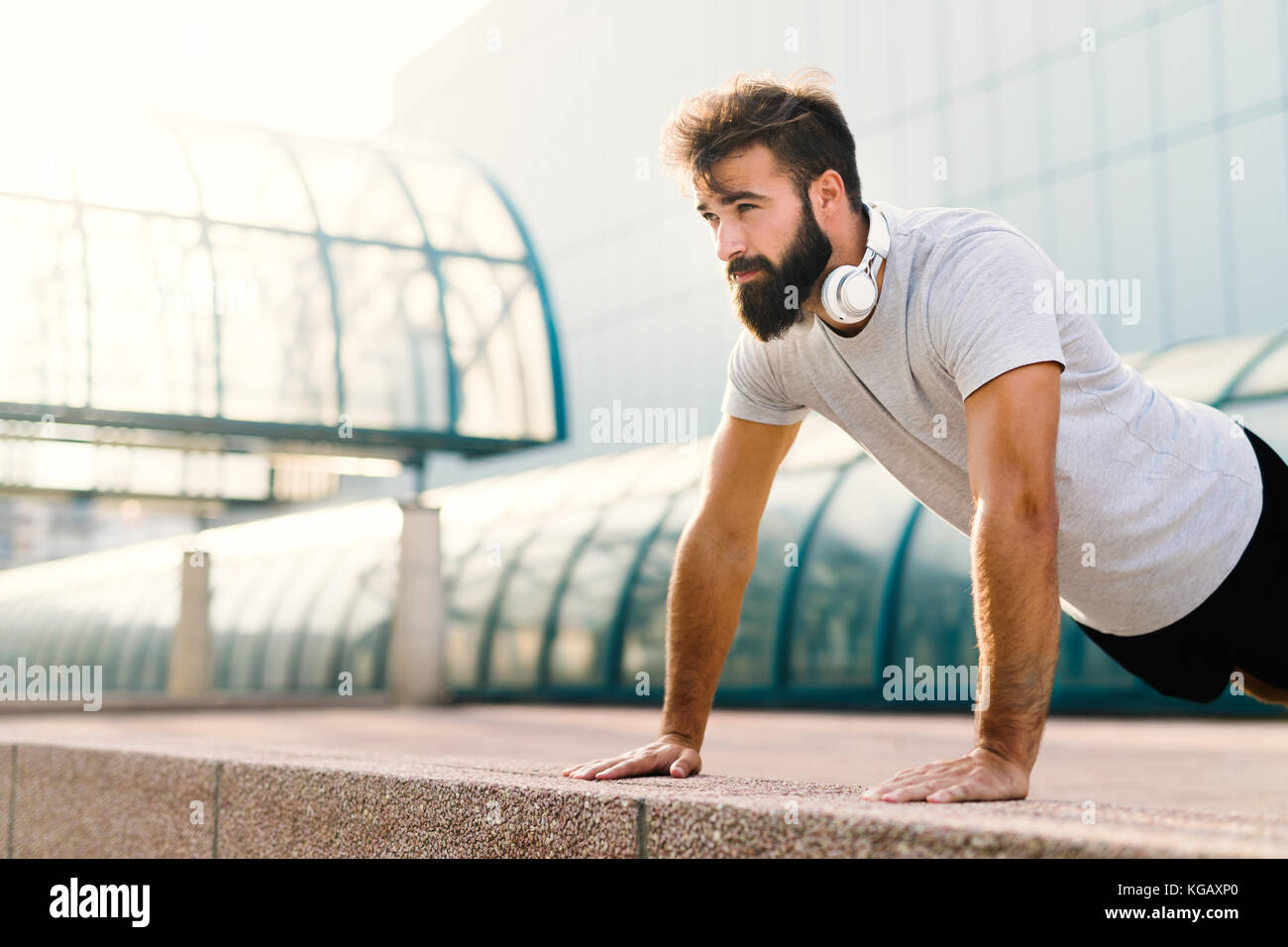 Handsome man doing push ups in urban area Stock Photo - Alamy
