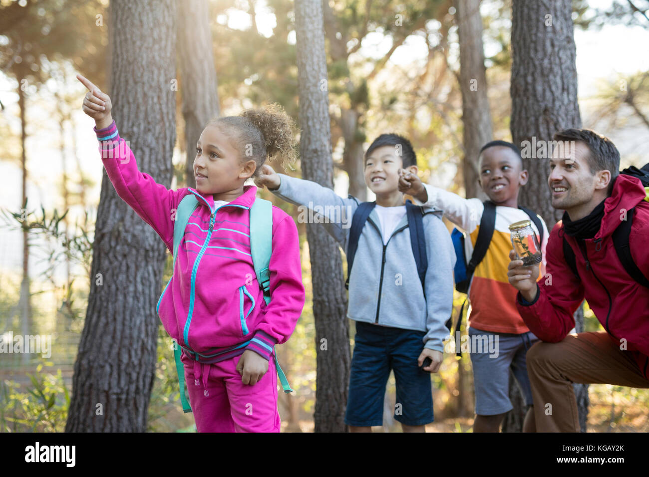 Kids pointing at distance in forest on a sunny day Stock Photo - Alamy