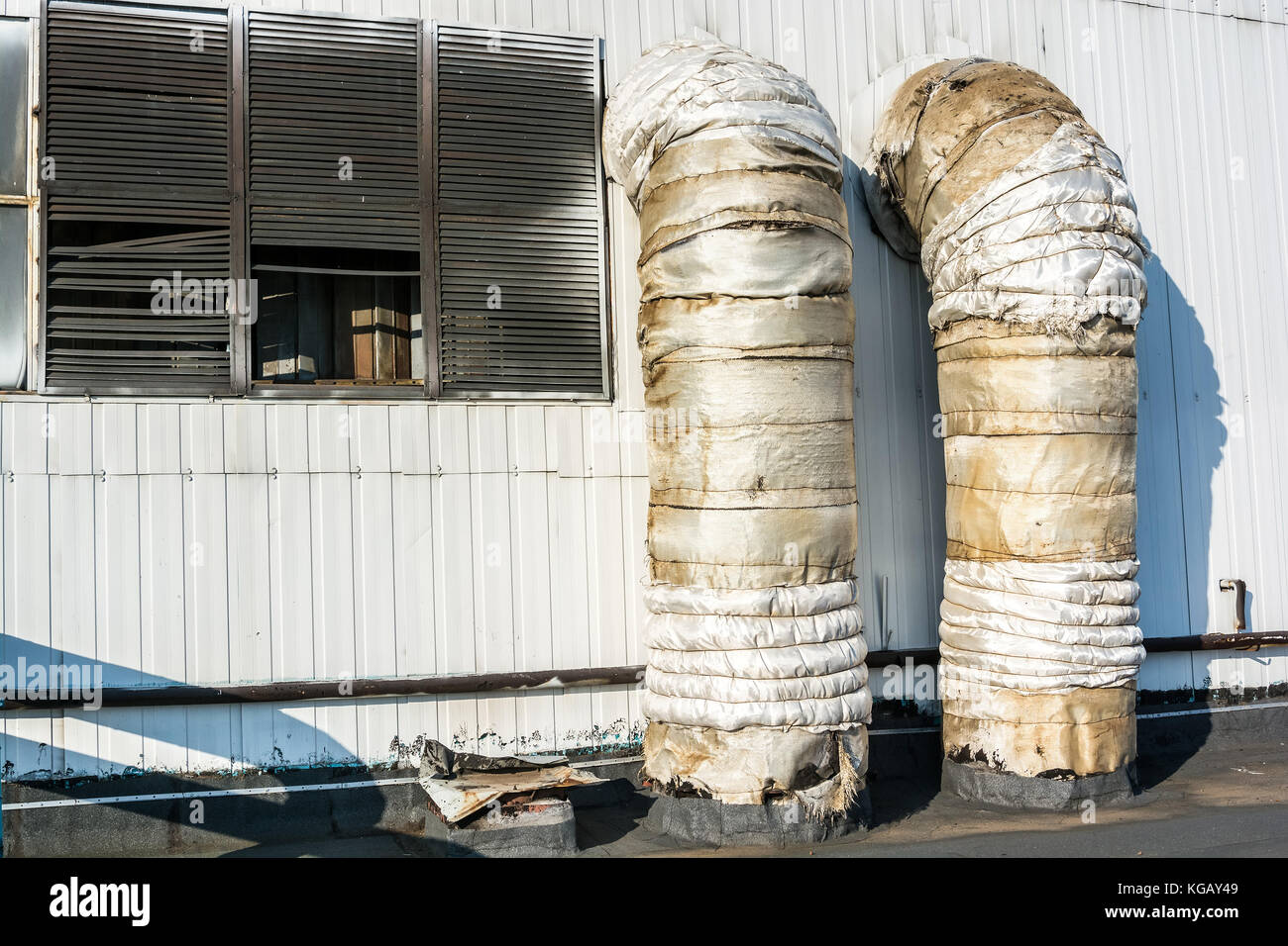 Close up wall of factory building and two big pipes Stock Photo - Alamy