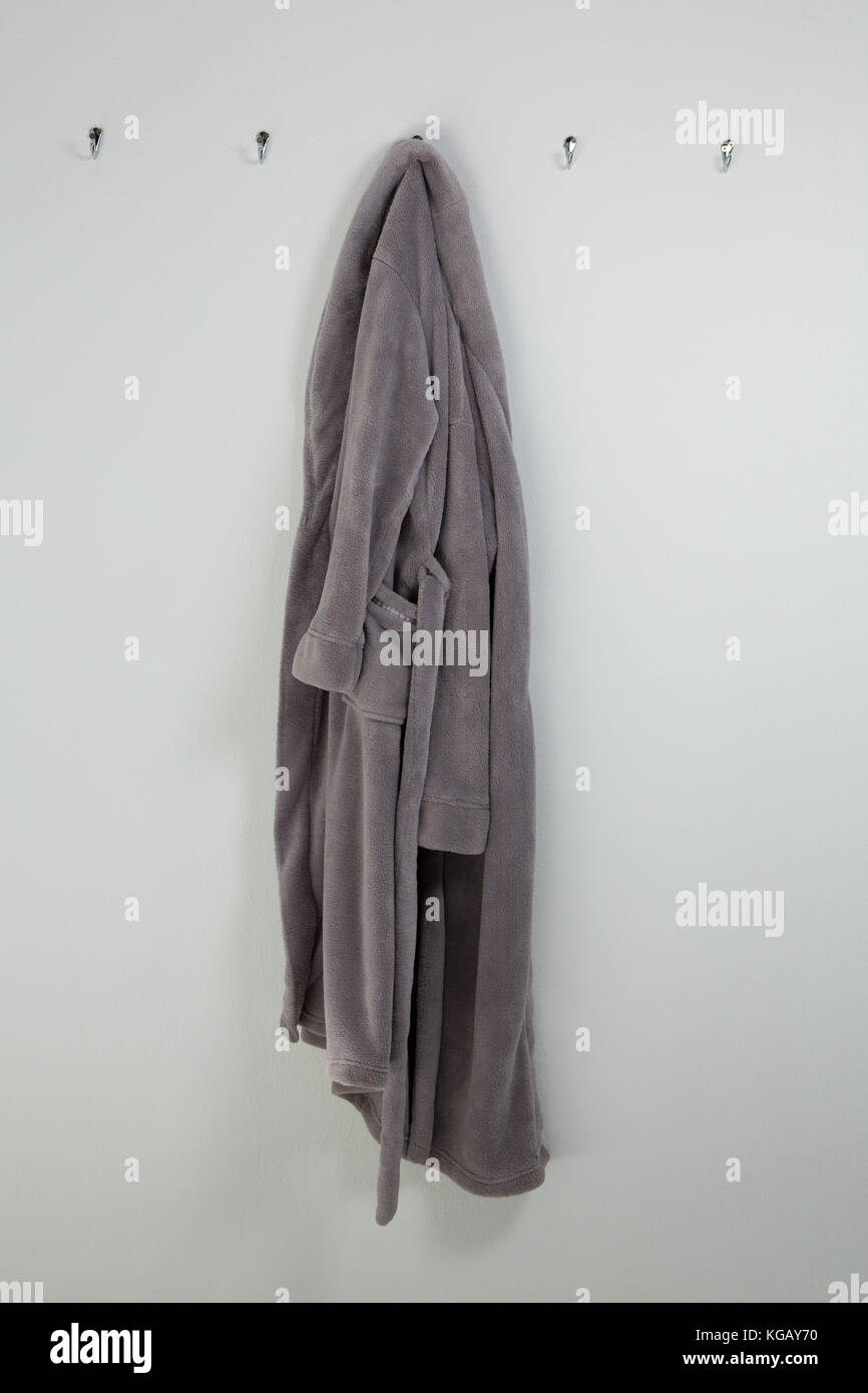 Bathrobe hanging on hook against wall Stock Photo - Alamy