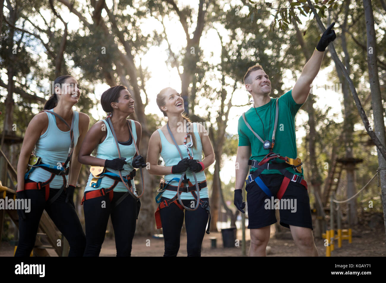 Coach assisting trainee in zip line on a sunny day Stock Photo - Alamy