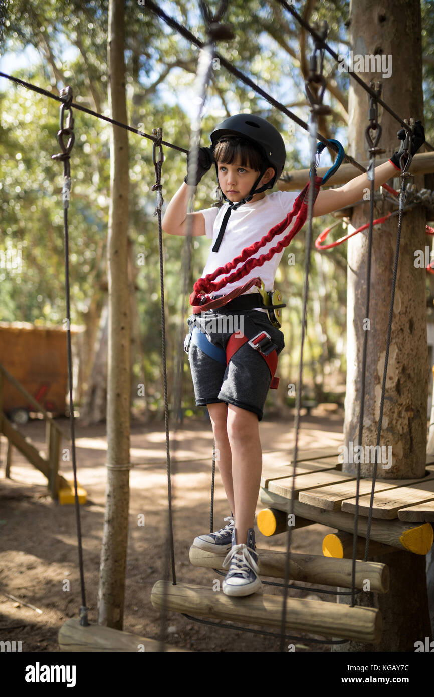 Determined boy crossing zip line on a sunny day Stock Photo - Alamy