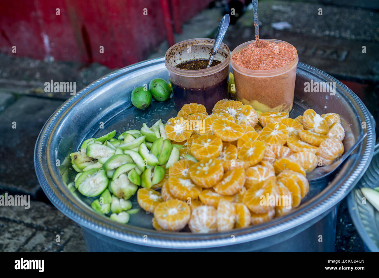 Street food in Yangon, Myanmar - fruit with salty sweet toppings Stock ...