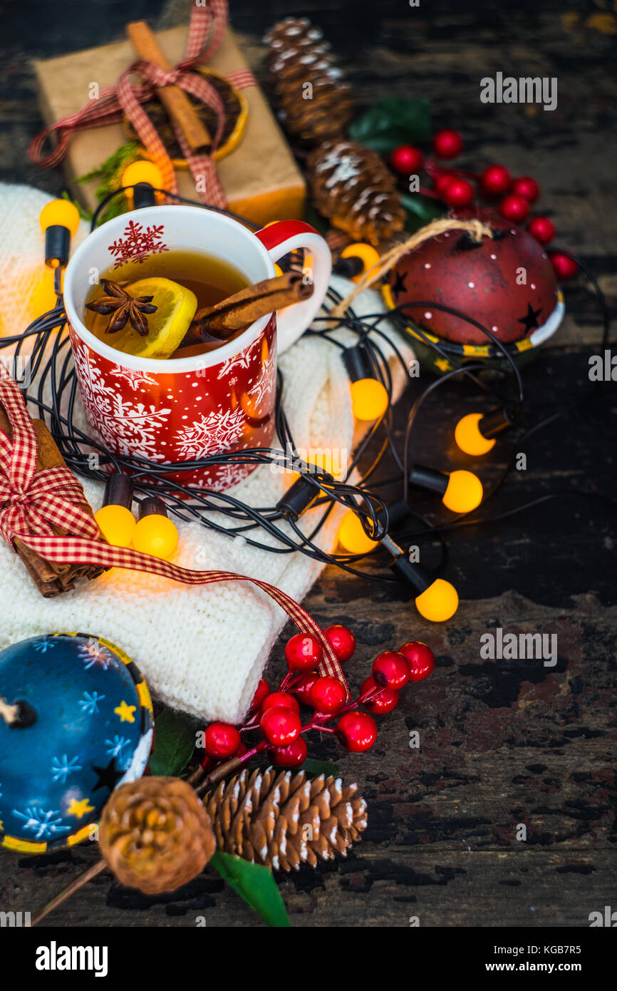 Red cup of teaa with lemon, Christmas lights and decoration on rustic ...