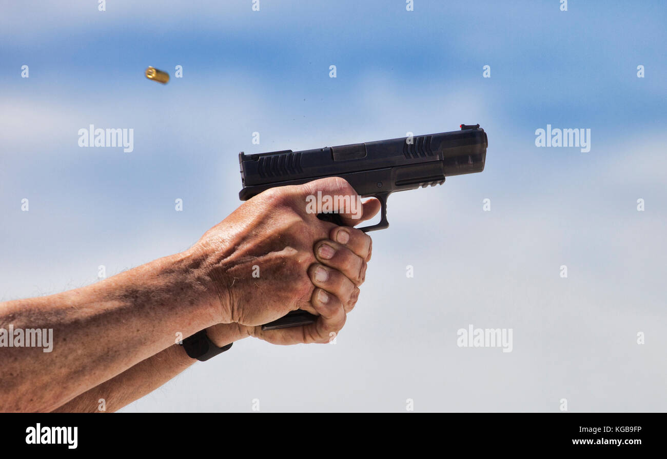 Brass flying toward the shooter as a pistol cycles Stock Photo - Alamy