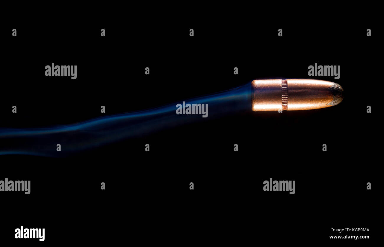 Bullet with smoke behind that is on a black background Stock Photo - Alamy