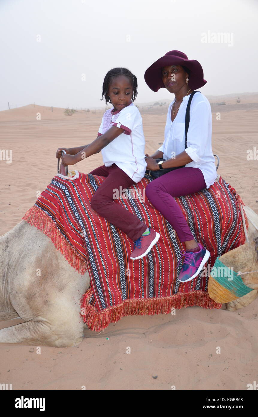 Tourists riding camel at the Desert Safari in Dubai,United Arab ...