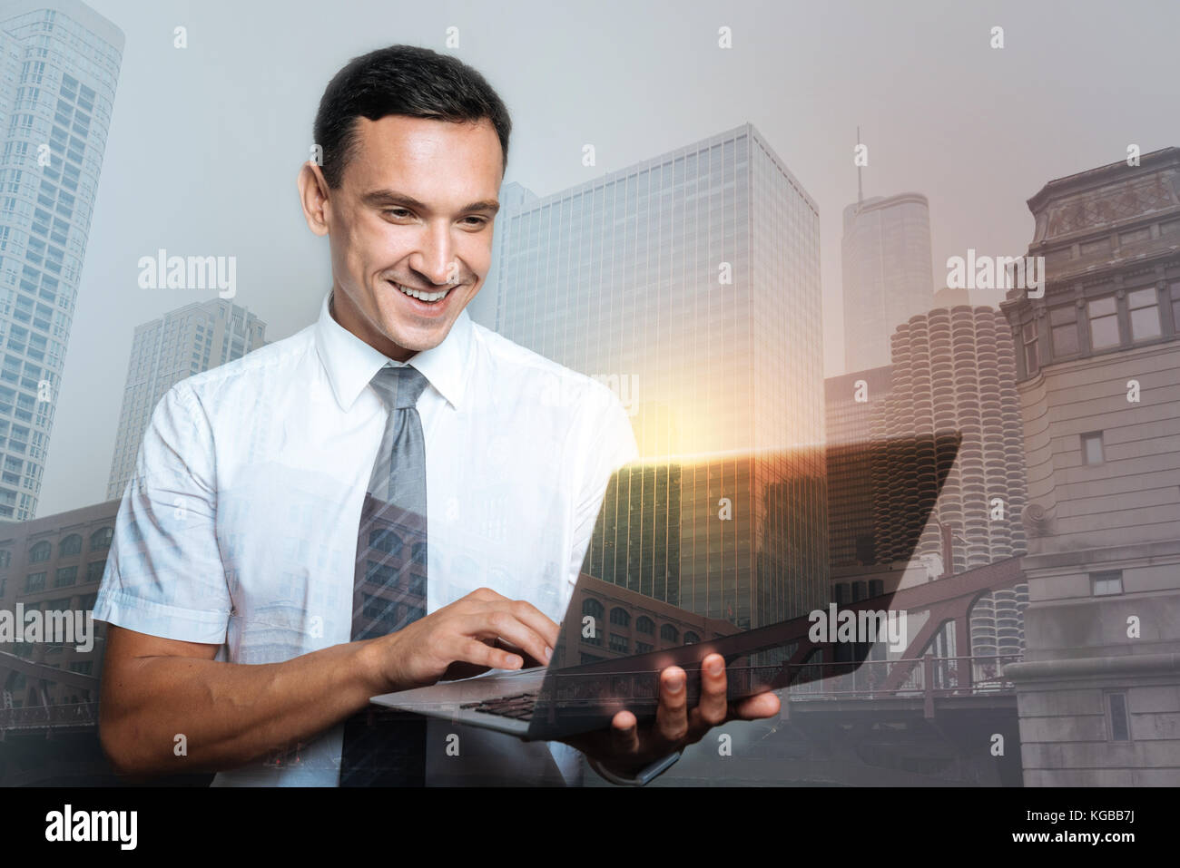 Nice positive man holding a laptop Stock Photo - Alamy