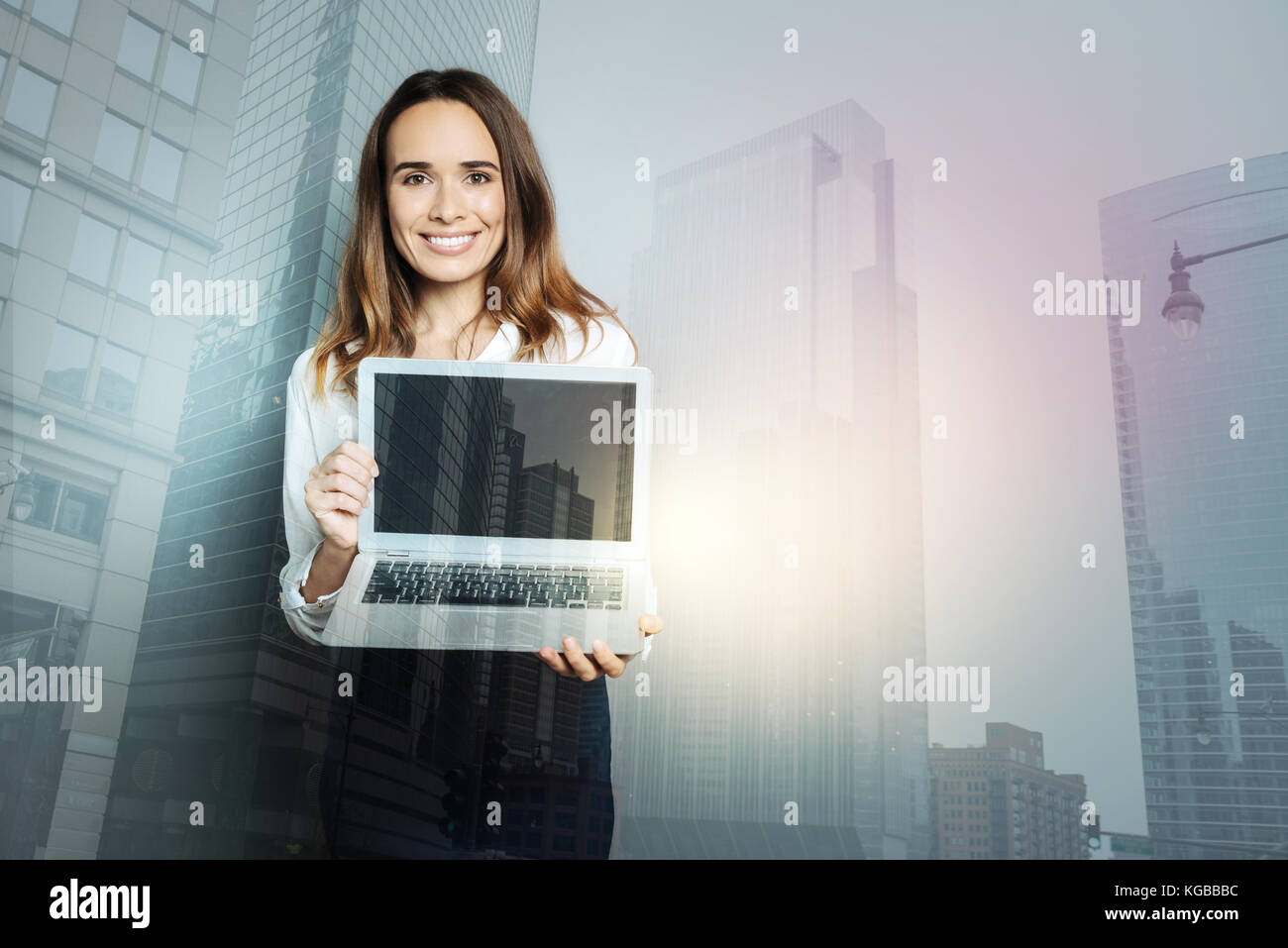 Happy professional woman holding a laptop Stock Photo - Alamy
