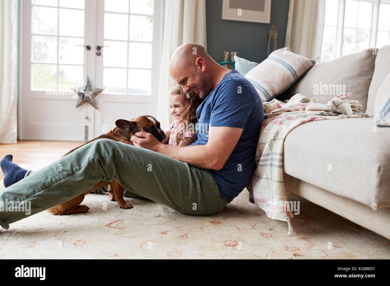 Father and daughter relaxing with their pet dog at home Stock Photo - Alamy
