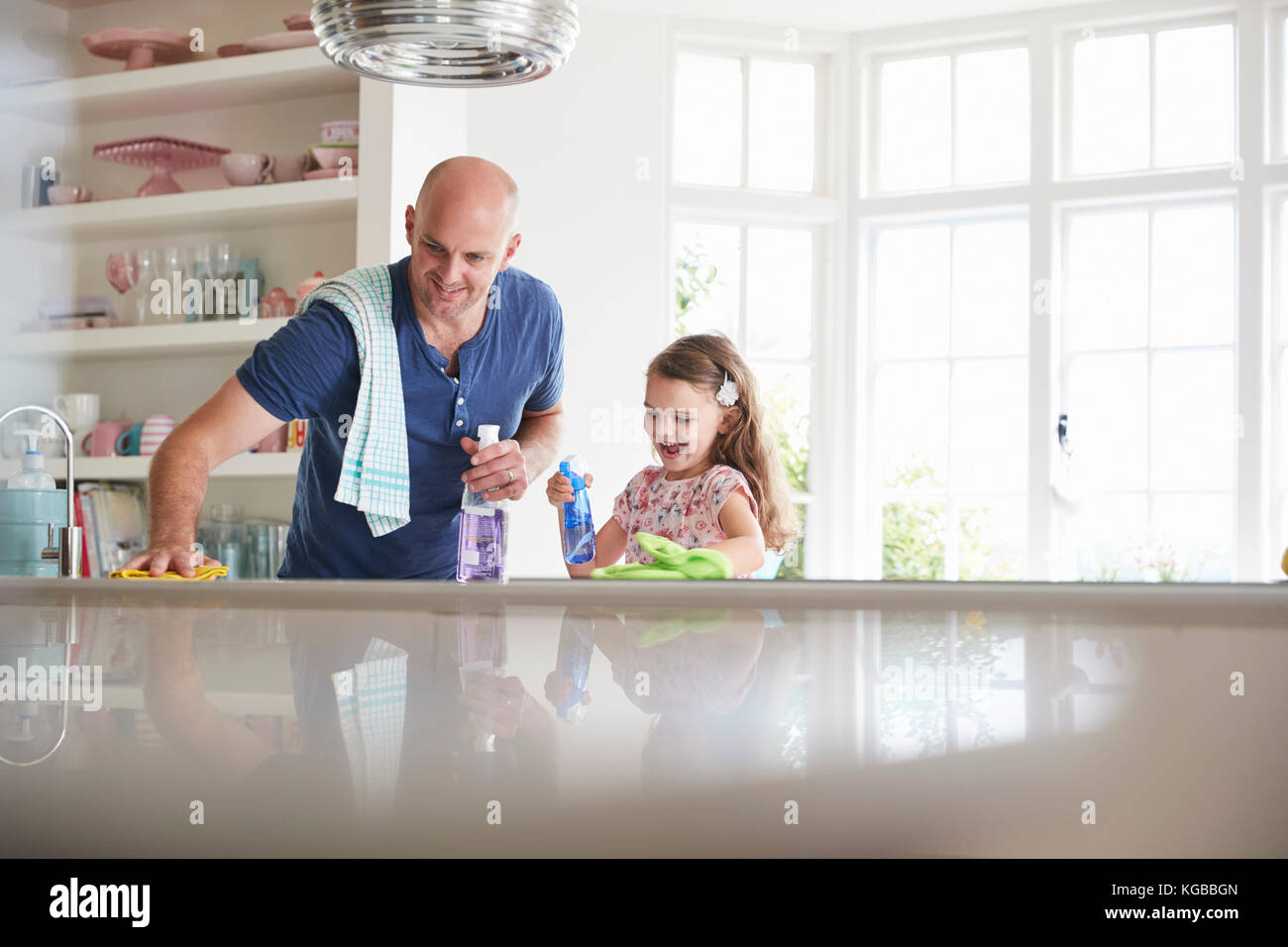 Father and daughter having fun while cleaning the kitchen Stock Photo ...