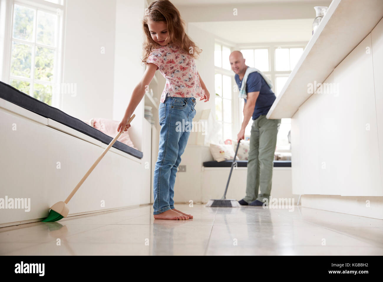Dad and daughter sweeping the kitchen floor together Stock Photo - Alamy