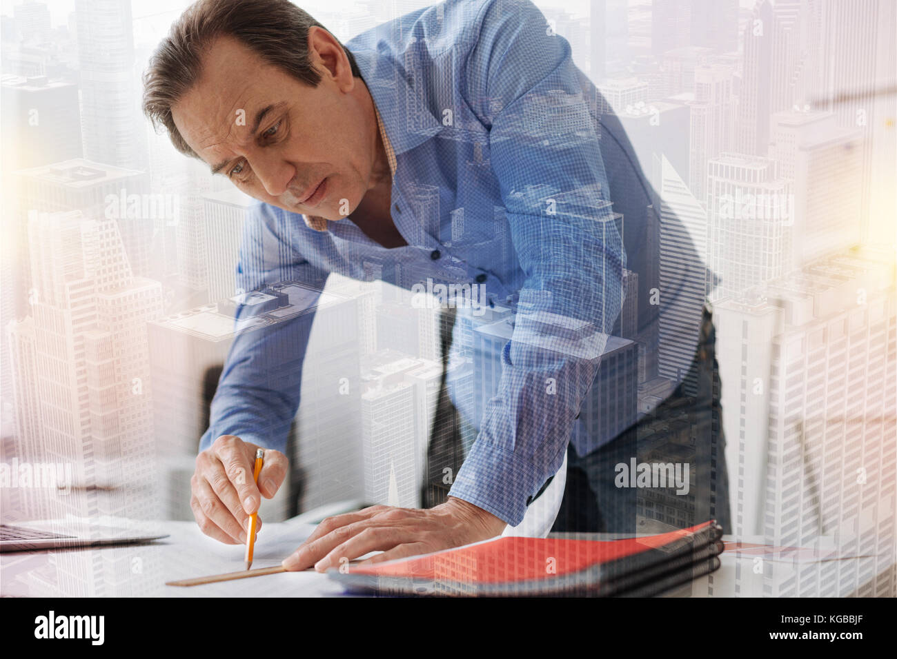 Concentrated professional engineer making a blueprint Stock Photo - Alamy