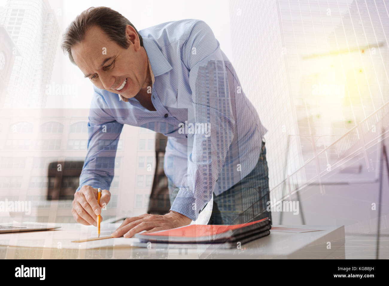 Positive male engineer drawing blueprint Stock Photo - Alamy