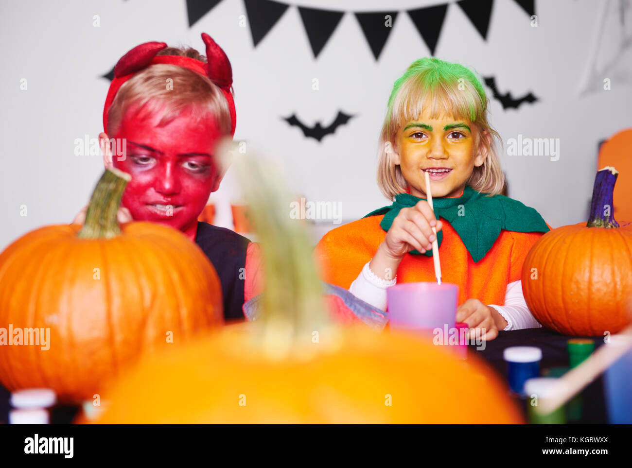 Painting a pumpkin is their favourite part of Halloween Stock Photo - Alamy