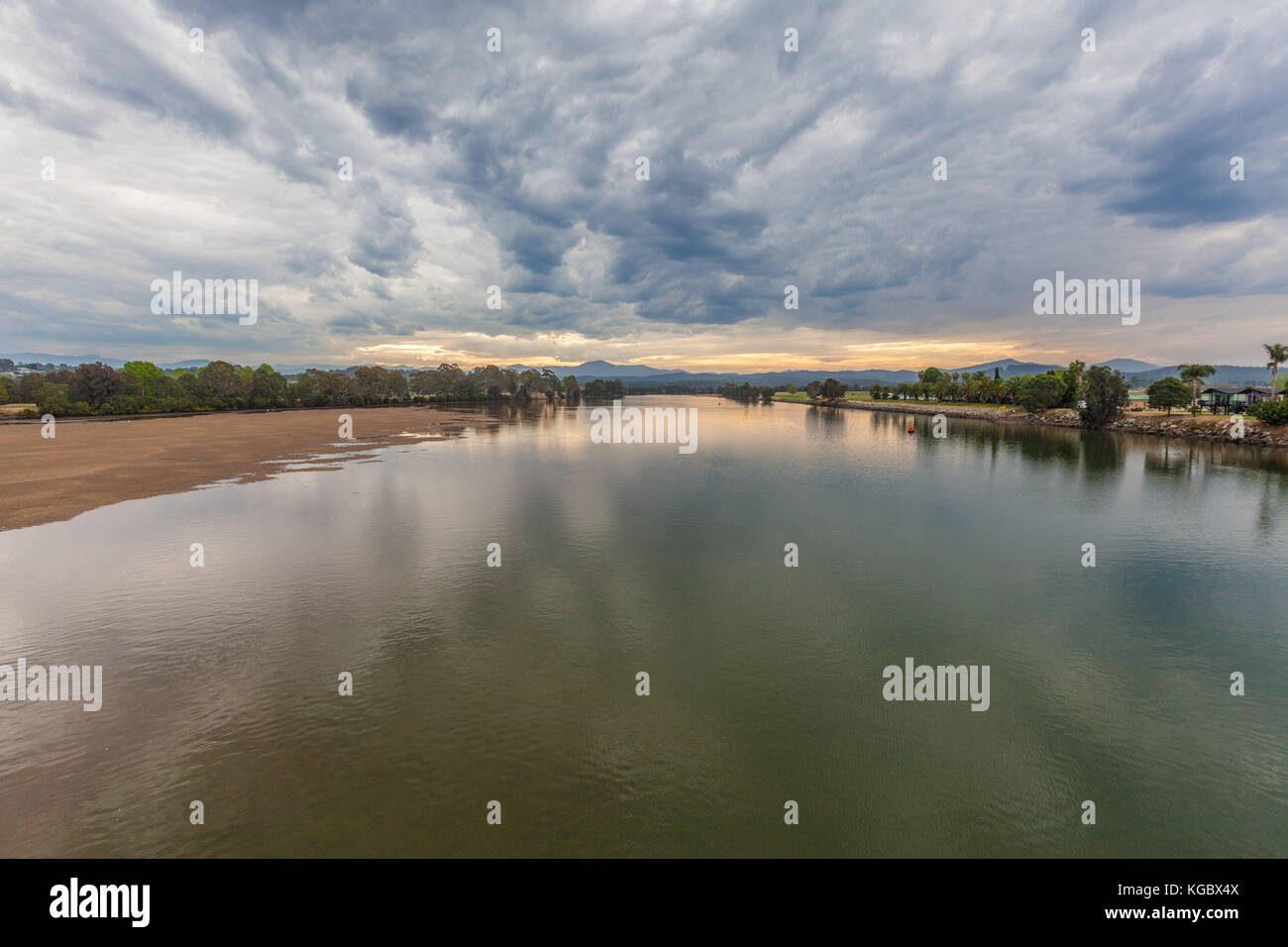 Landscape of river with trees and overcast skies at sunset Stock Photo ...