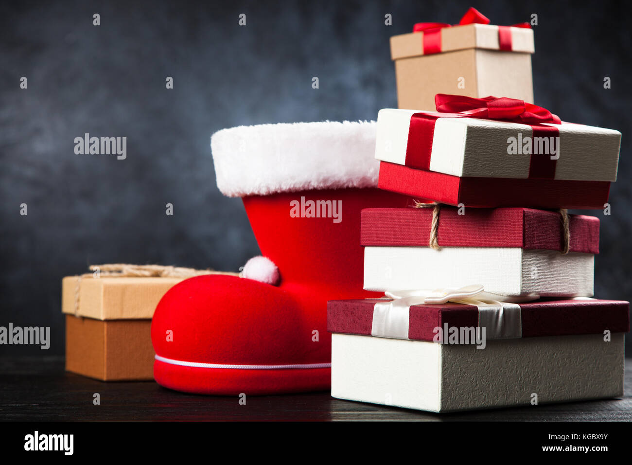 Santa's shoe with gifts boxes on dark background Stock Photo - Alamy
