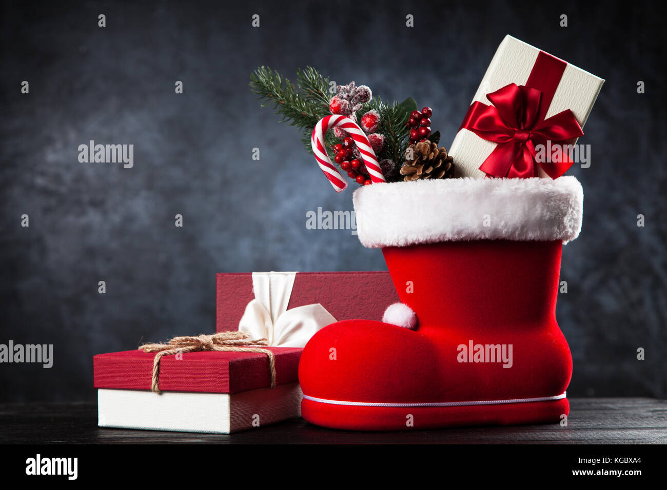Santa's shoe with gifts boxes on dark background Stock Photo - Alamy