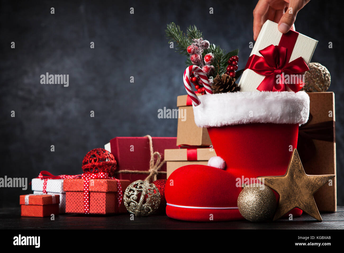 Santa's shoe with gifts boxes on dark background Stock Photo - Alamy