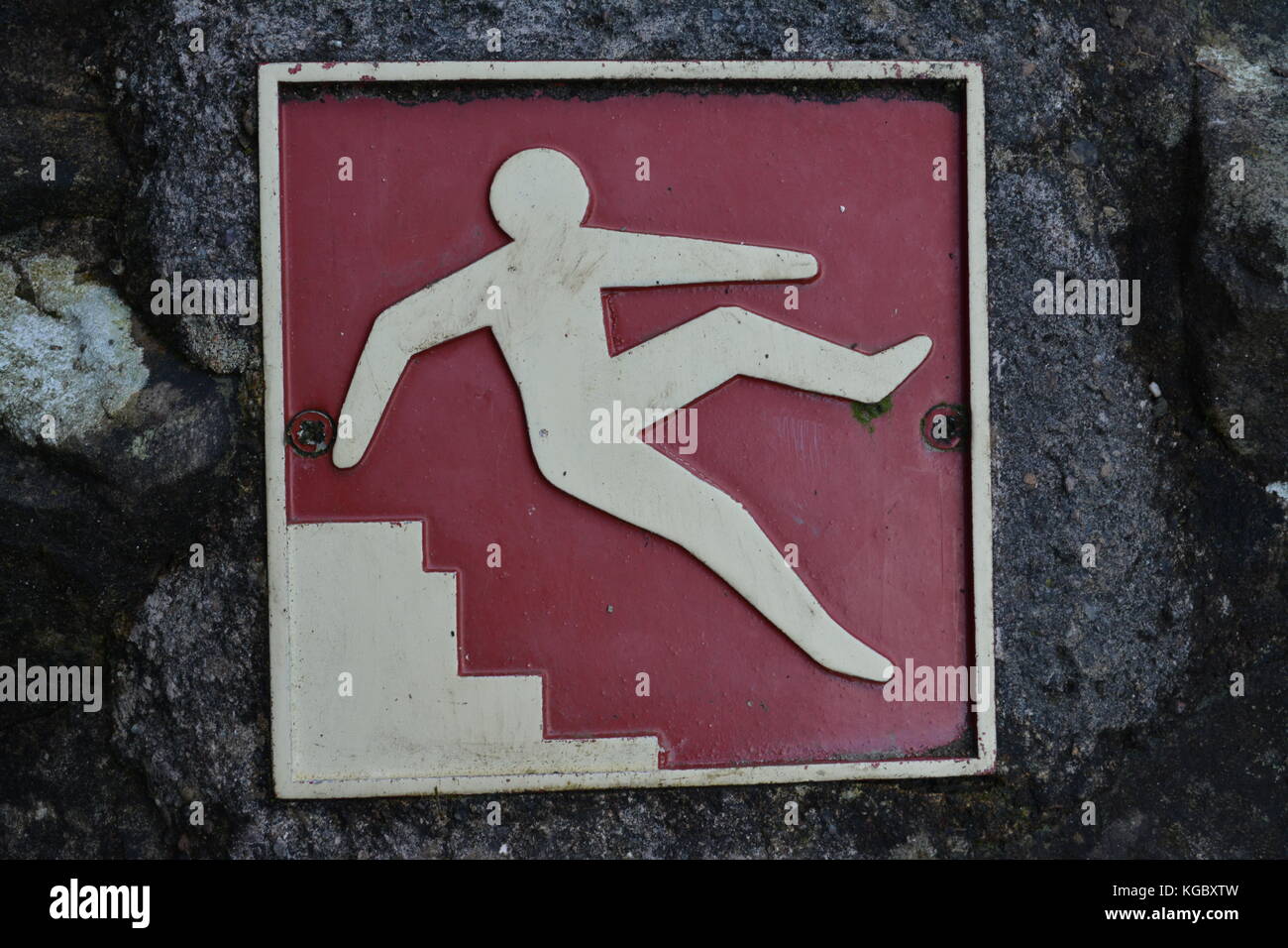 old square metal sign with red and white paint showing figure falling ...