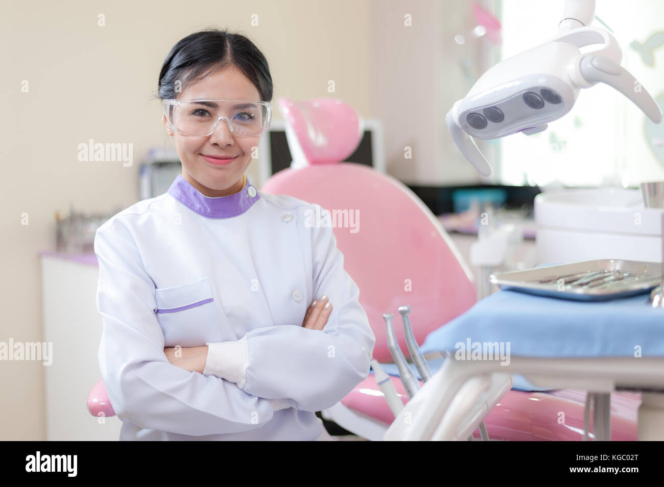 Female dentist crossing arm while standing in front of dental ...