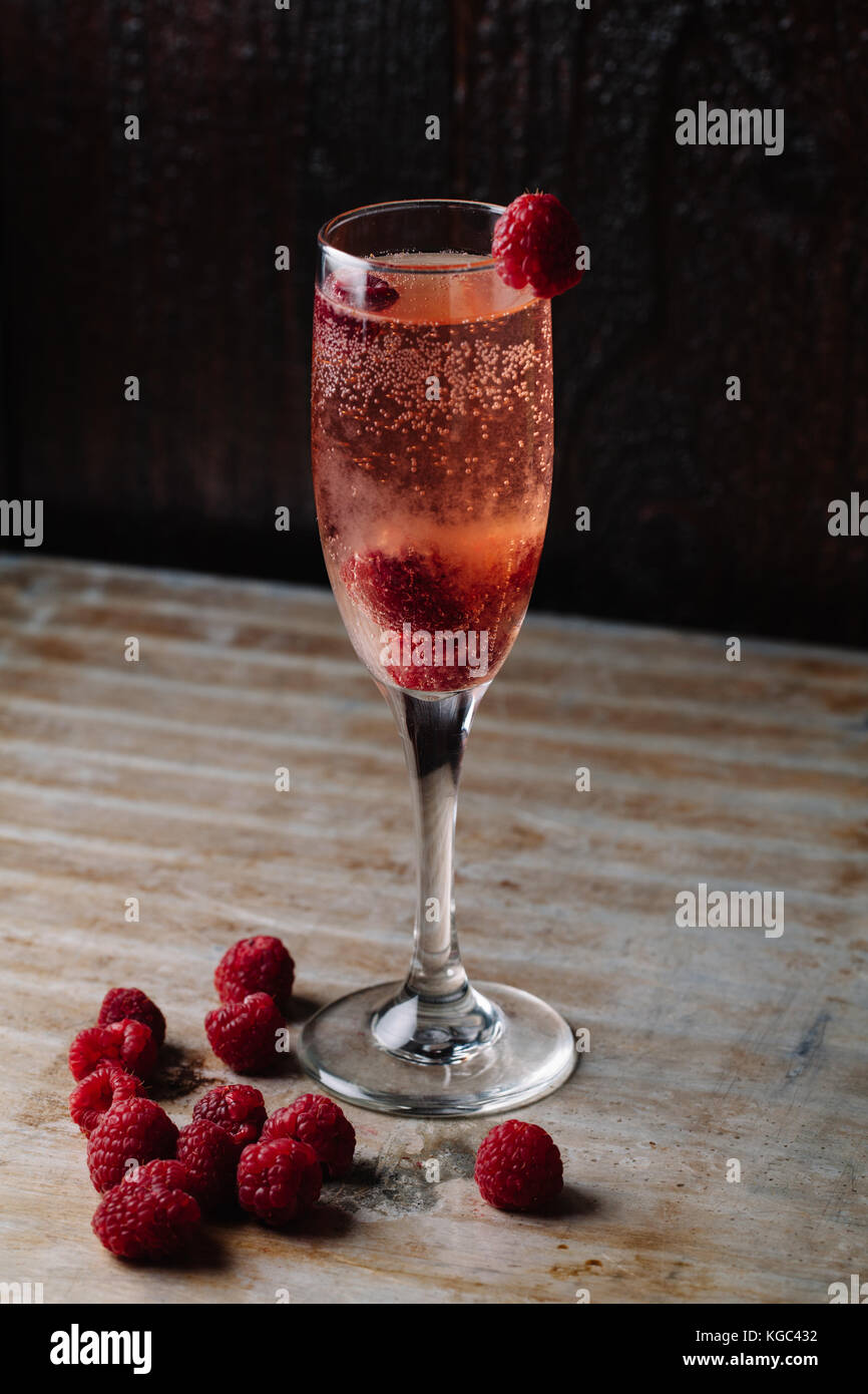 A glass of raspberry champagne on rustic background Stock Photo - Alamy